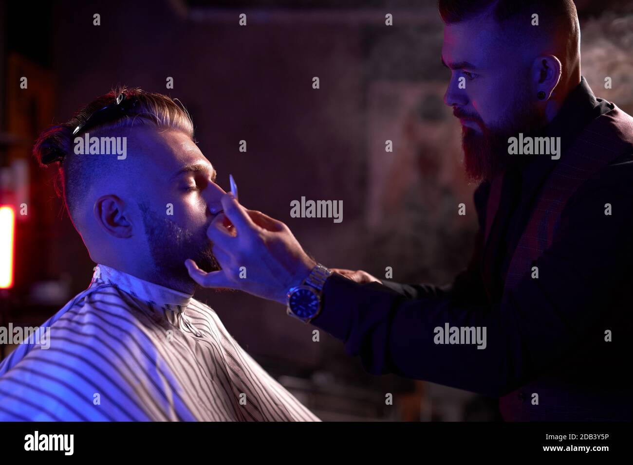 young caucasian handsome man on chair of barber having procedure of ...