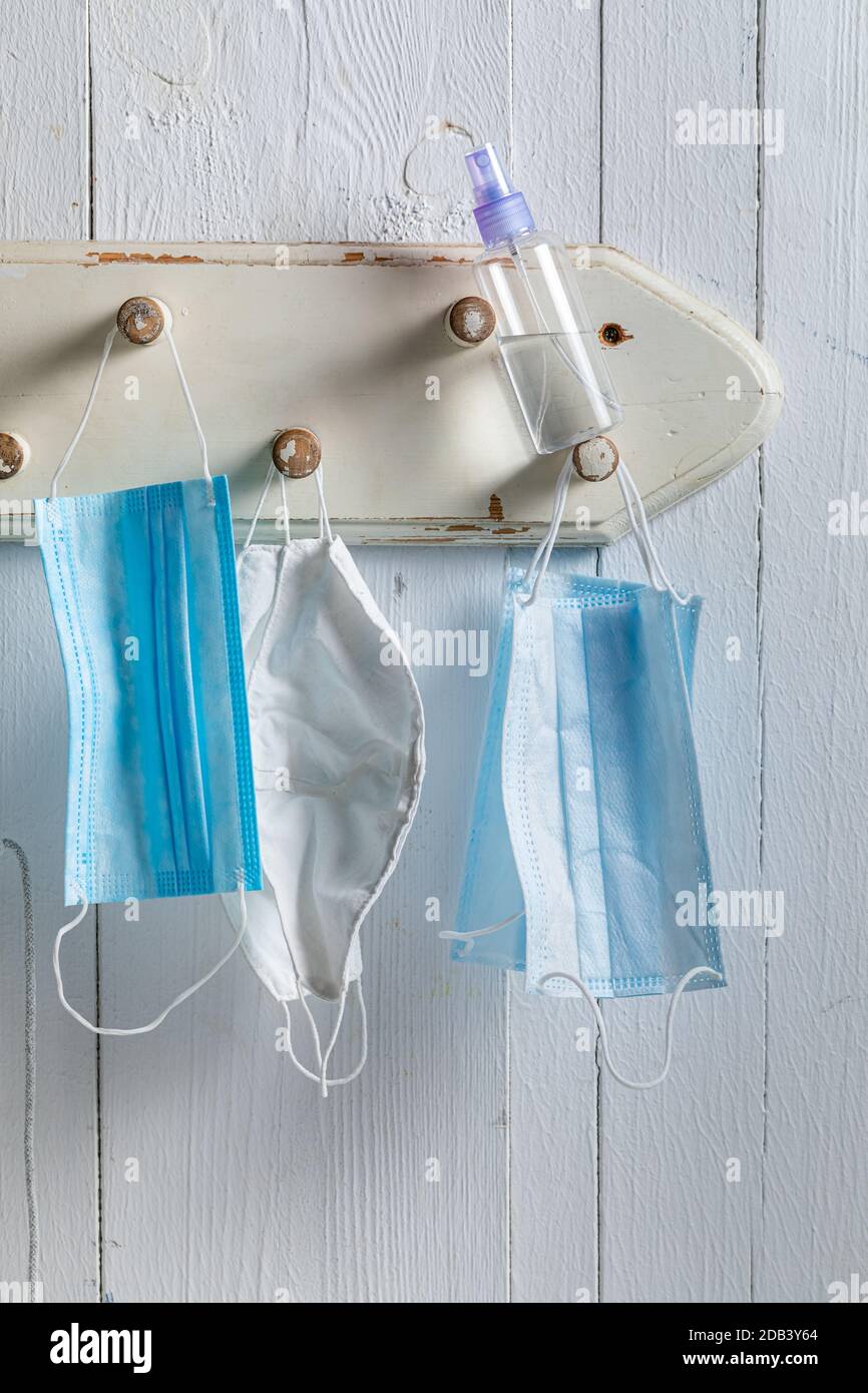 Medical masks and liquid disinfection hanging on white hanger for ...