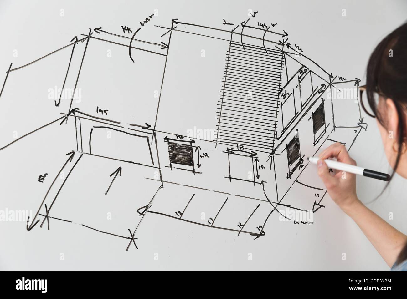 Close-up of a young female architect drawing a sketch for a new famaly ...