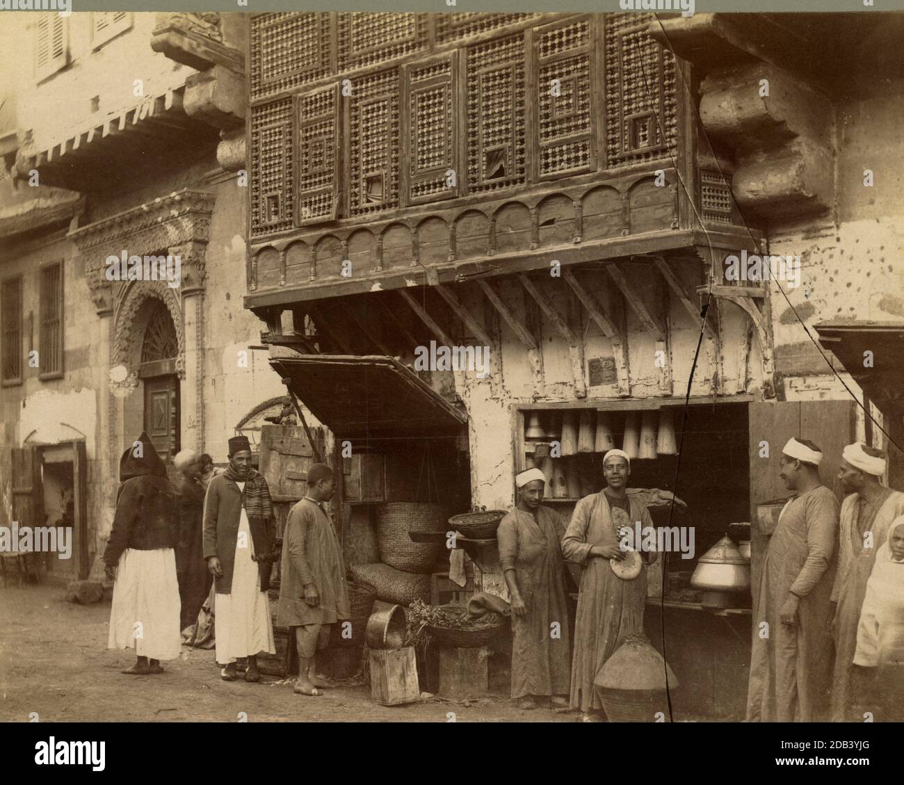 Men standing next to shop stall open to street Stock Photo - Alamy