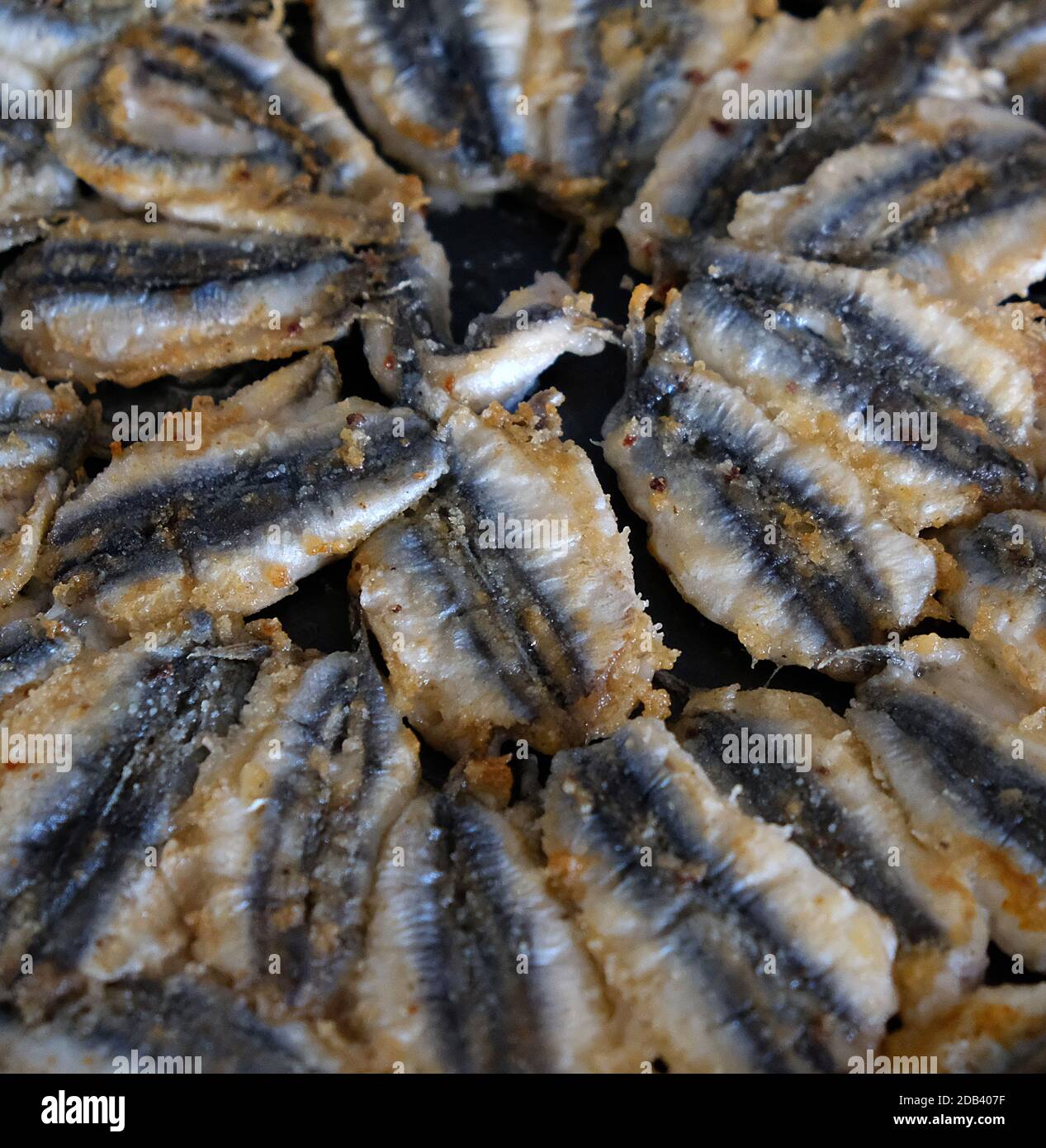 anchovy fish cooked on a stove, cooking anchovy in a pan, anchovy in a ...