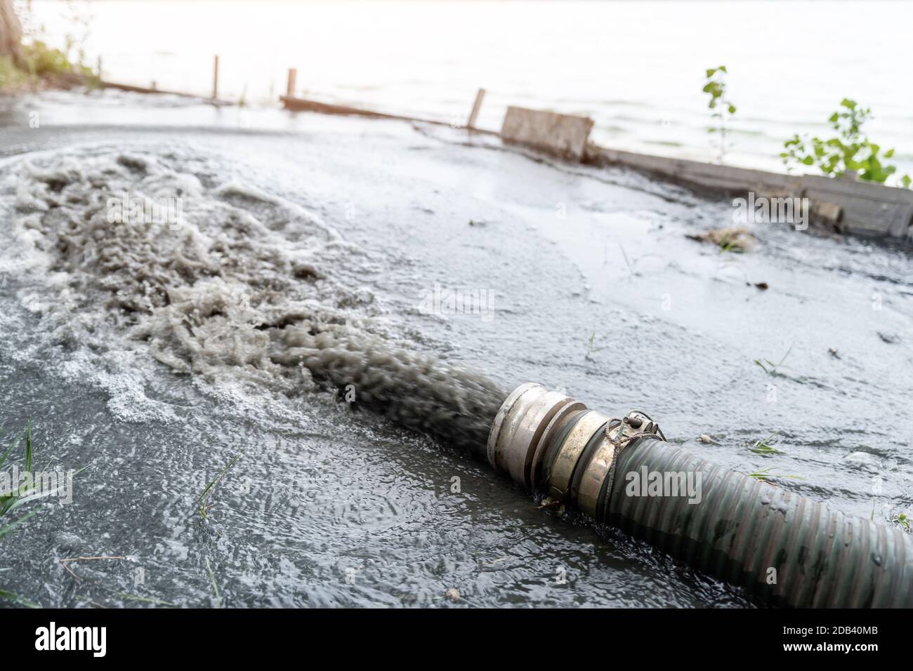 Close-up big pipe of power pump machine pouring mud sludge waste water ...