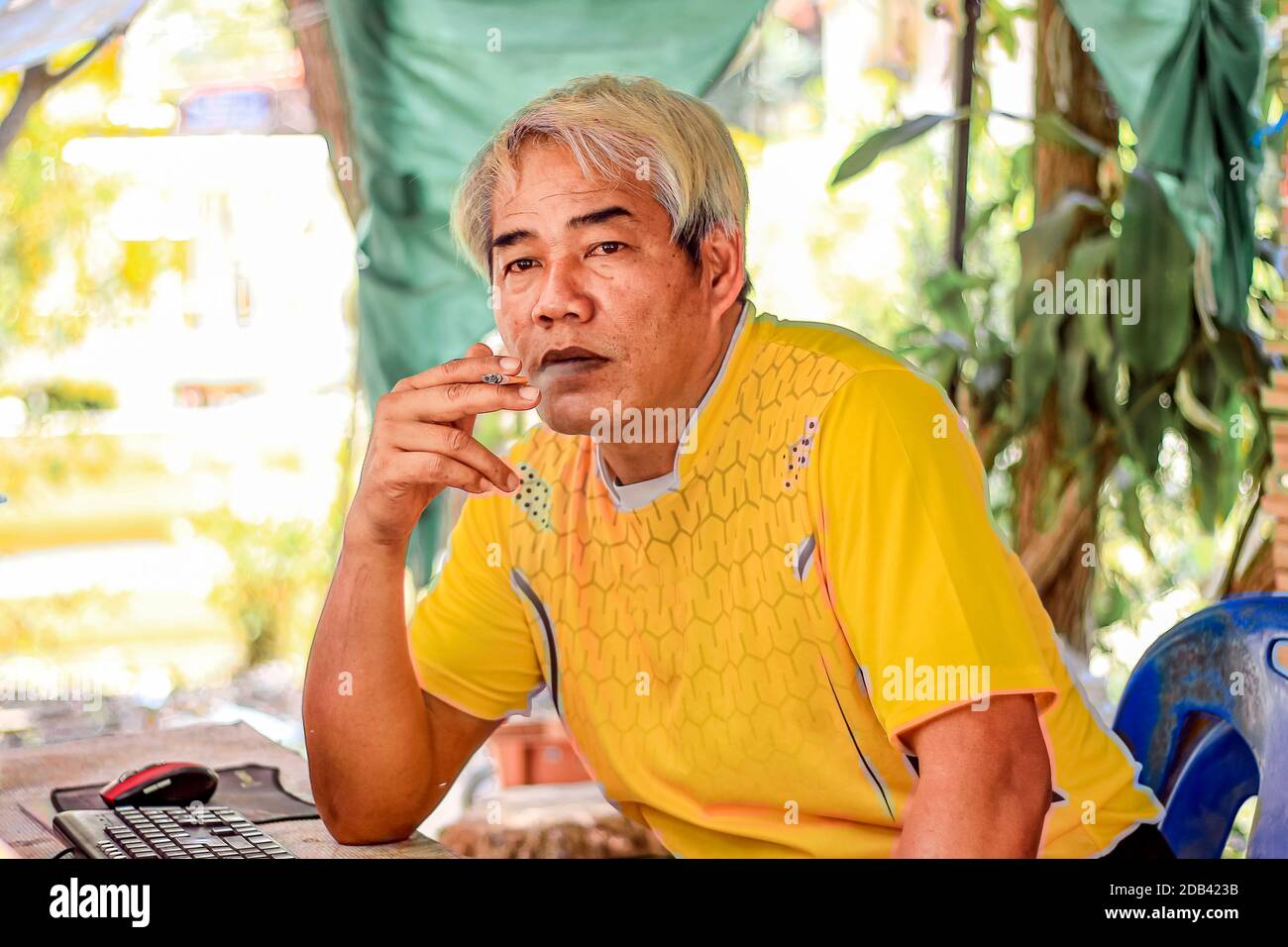 man solemnly smoking a cigarette in staring on front of him with smoke ...