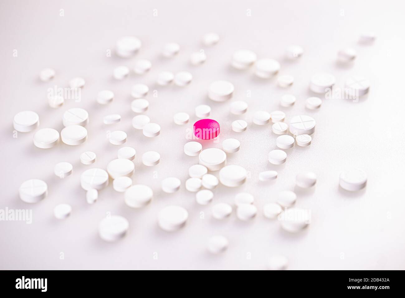 White medicinal pills with a single magenta pill in the center. Special ...