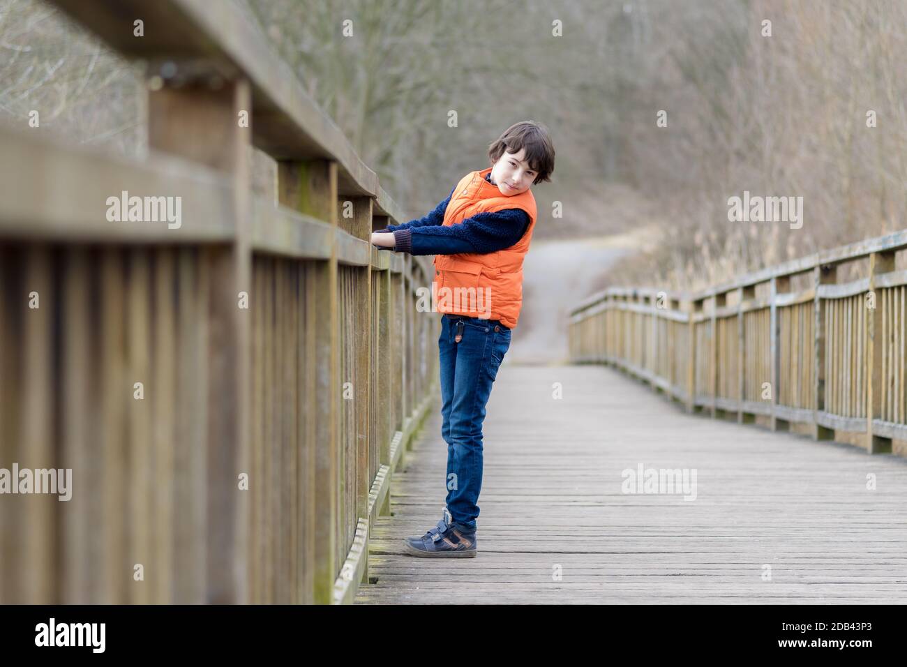 Portrait of a handsome boy standing on a wooden bridge Stock Photo - Alamy