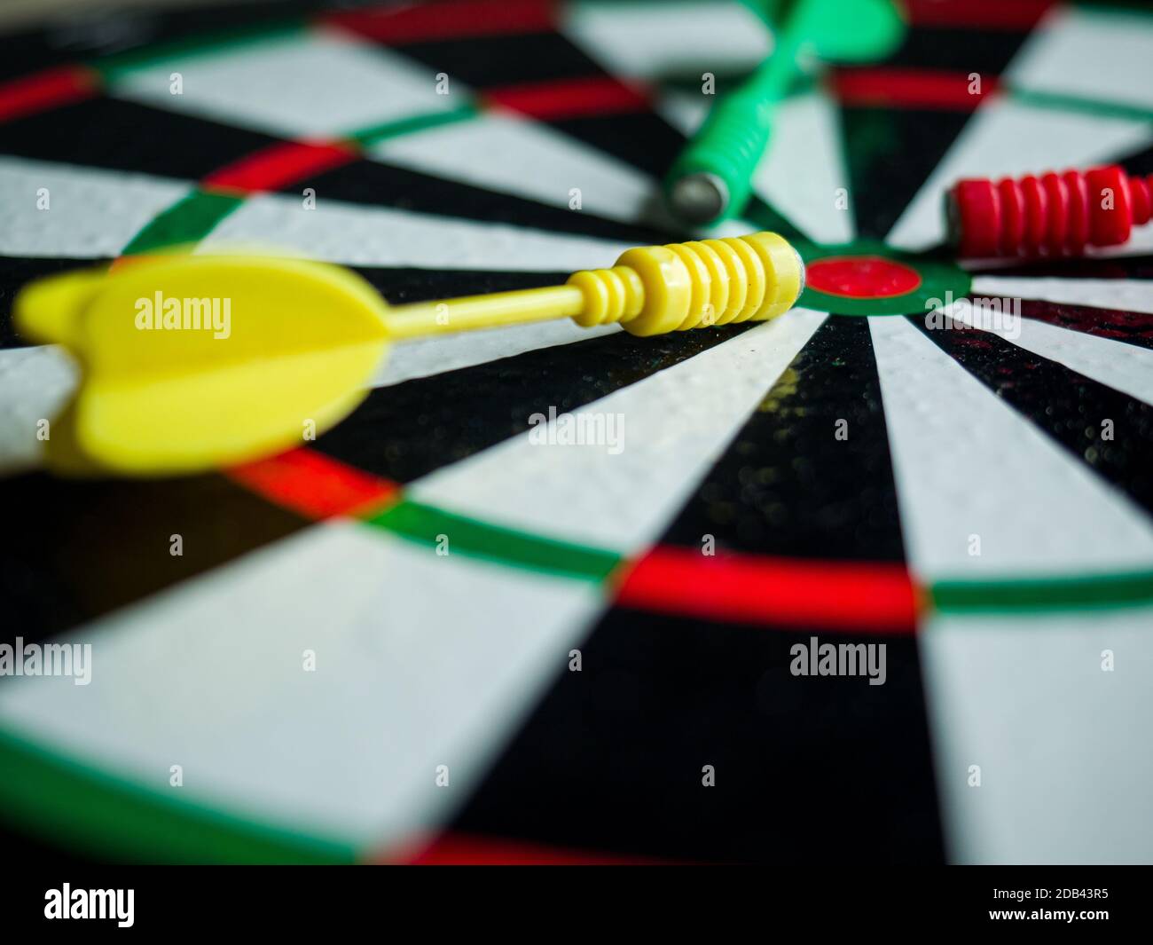 A closeup shot of three colored darts on a dartboard Stock Photo - Alamy