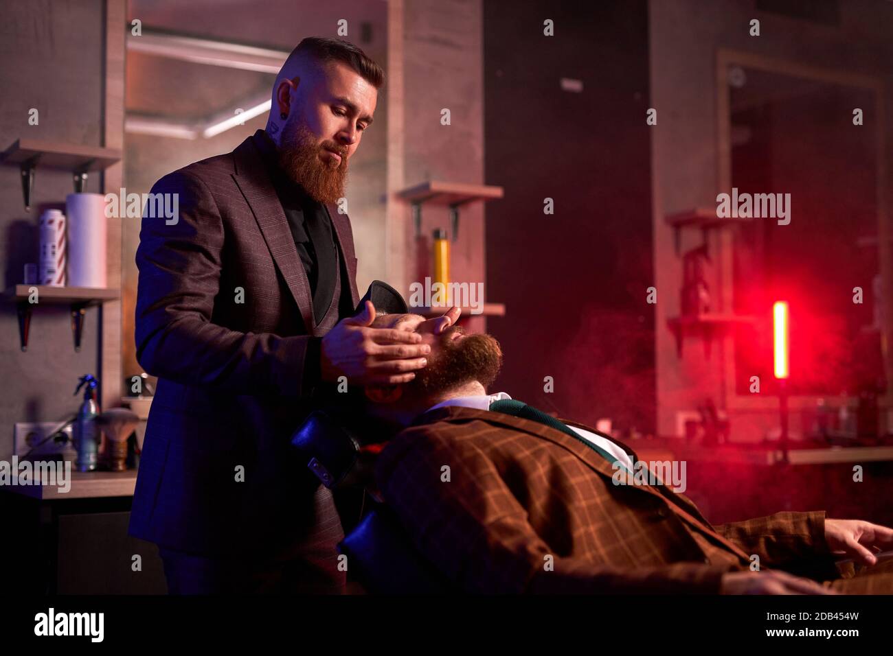 young caucasian handsome man on chair of barber having procedure of ...