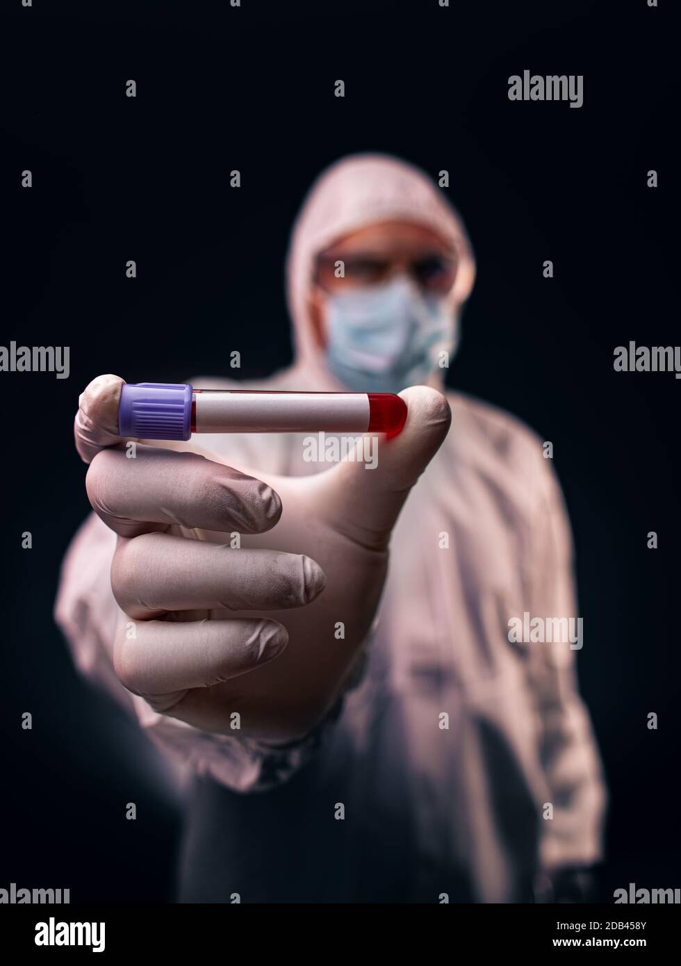Test tube with blood sample. Scientist with biohazard protection cloth ...