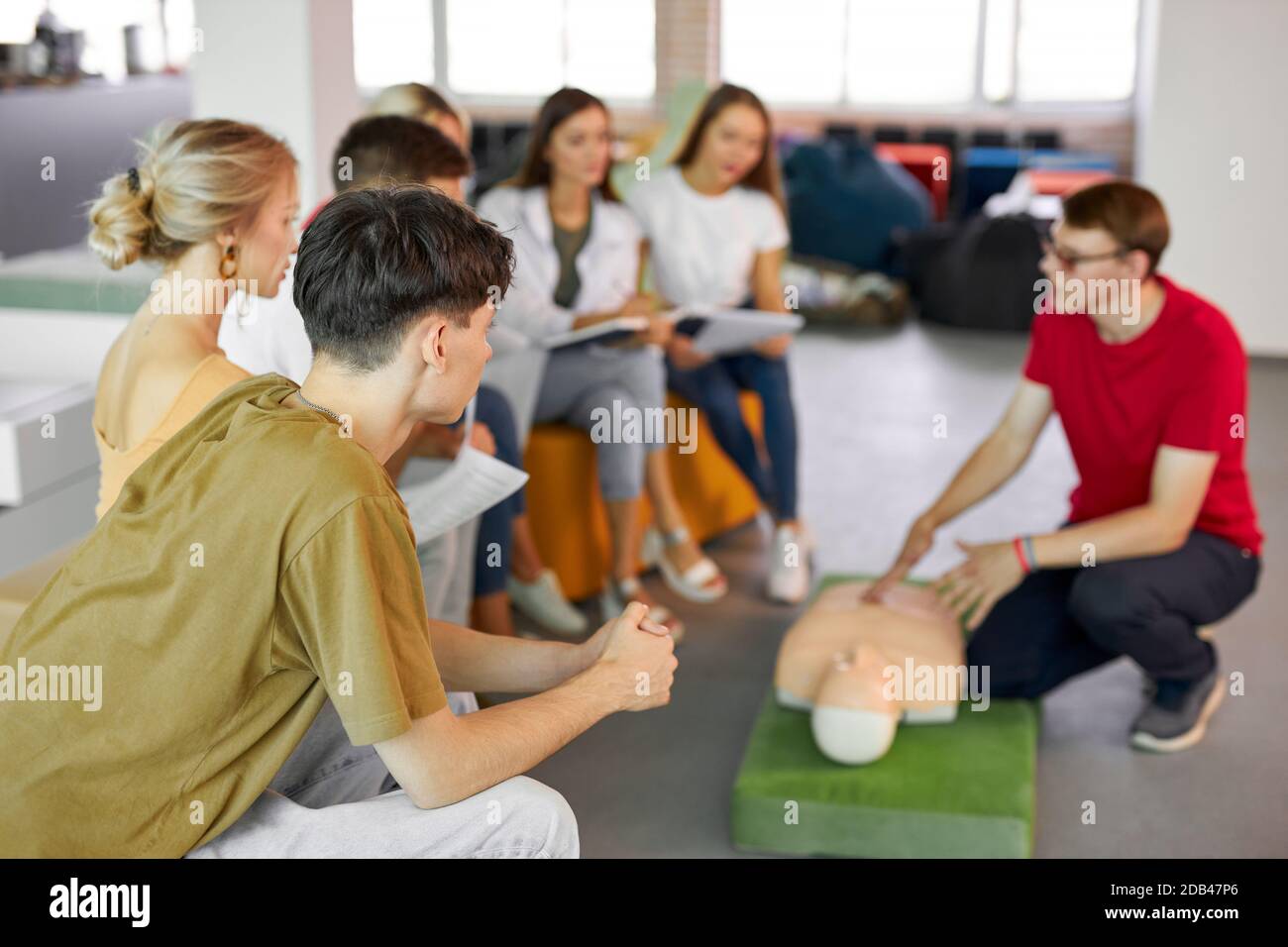 CPR class with male instructor speaking and demonstrating help, giving ...