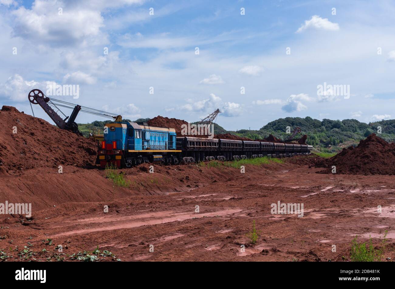 Excavator loading clay to the train on the opencast mining site Stock ...