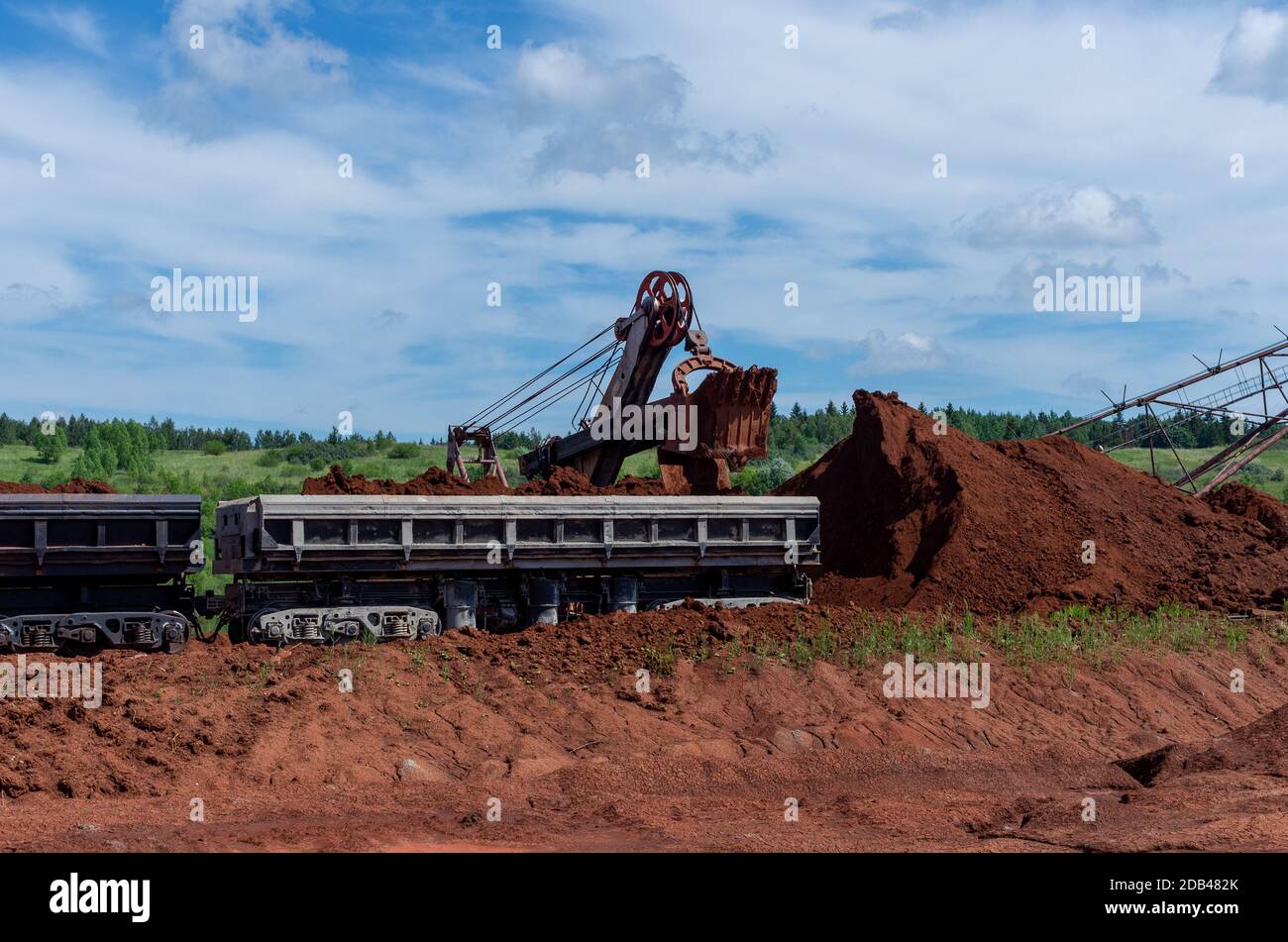 Excavator loading clay to the train on the opencast mining site Stock ...