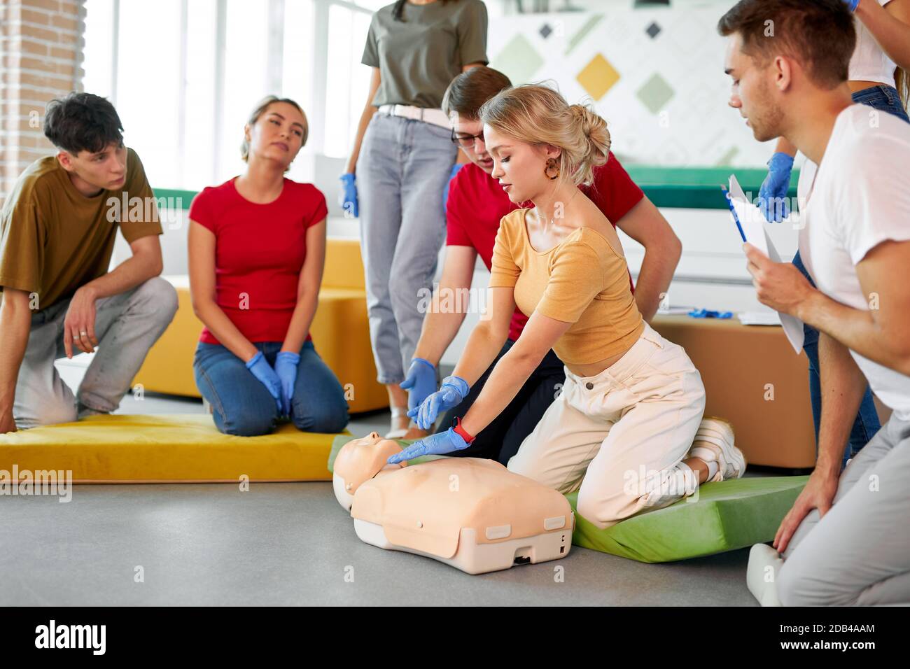 CPR class with young caucasian instructors speaking and demonstrating ...