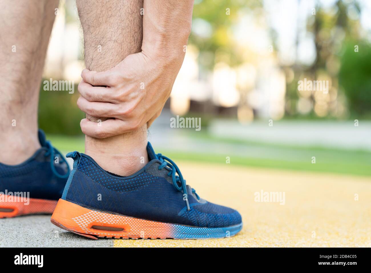 Male runner athlete leg injury and pain. Hands grab painful leg while ...