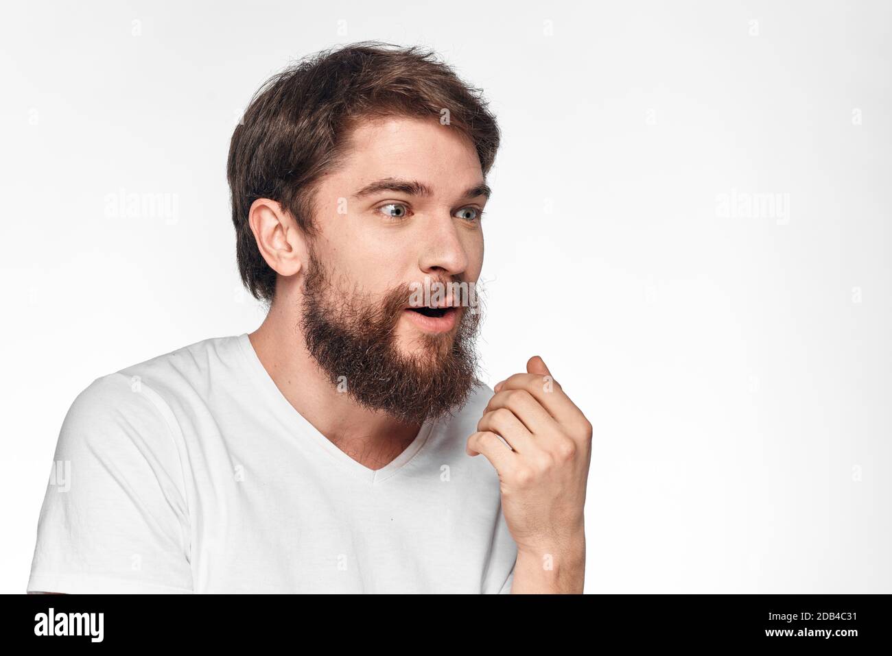 cheerful emotional bearded man gesturing with his hands close-up light ...
