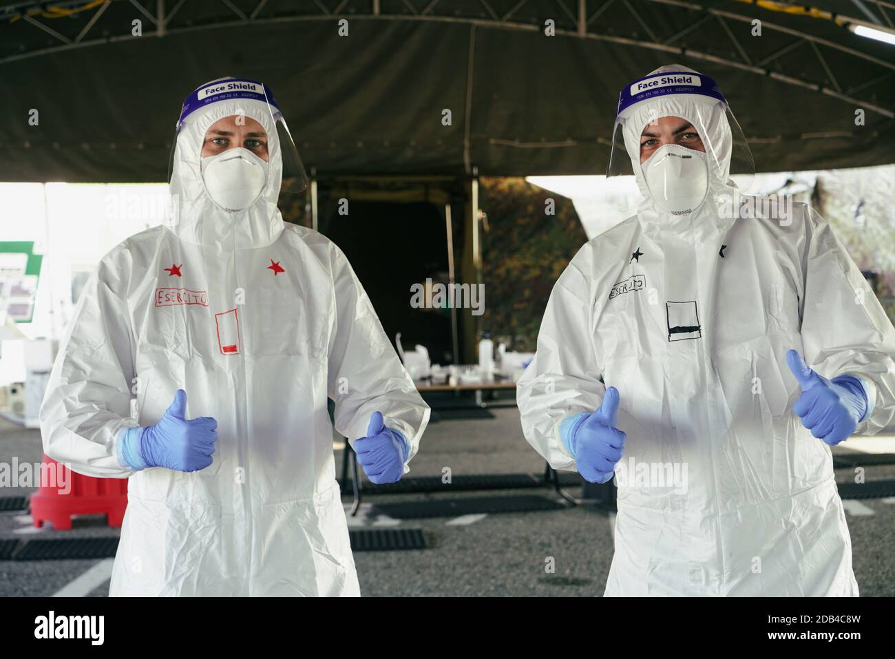 Two doctors with white disposable overalls and a protective covid mask ...