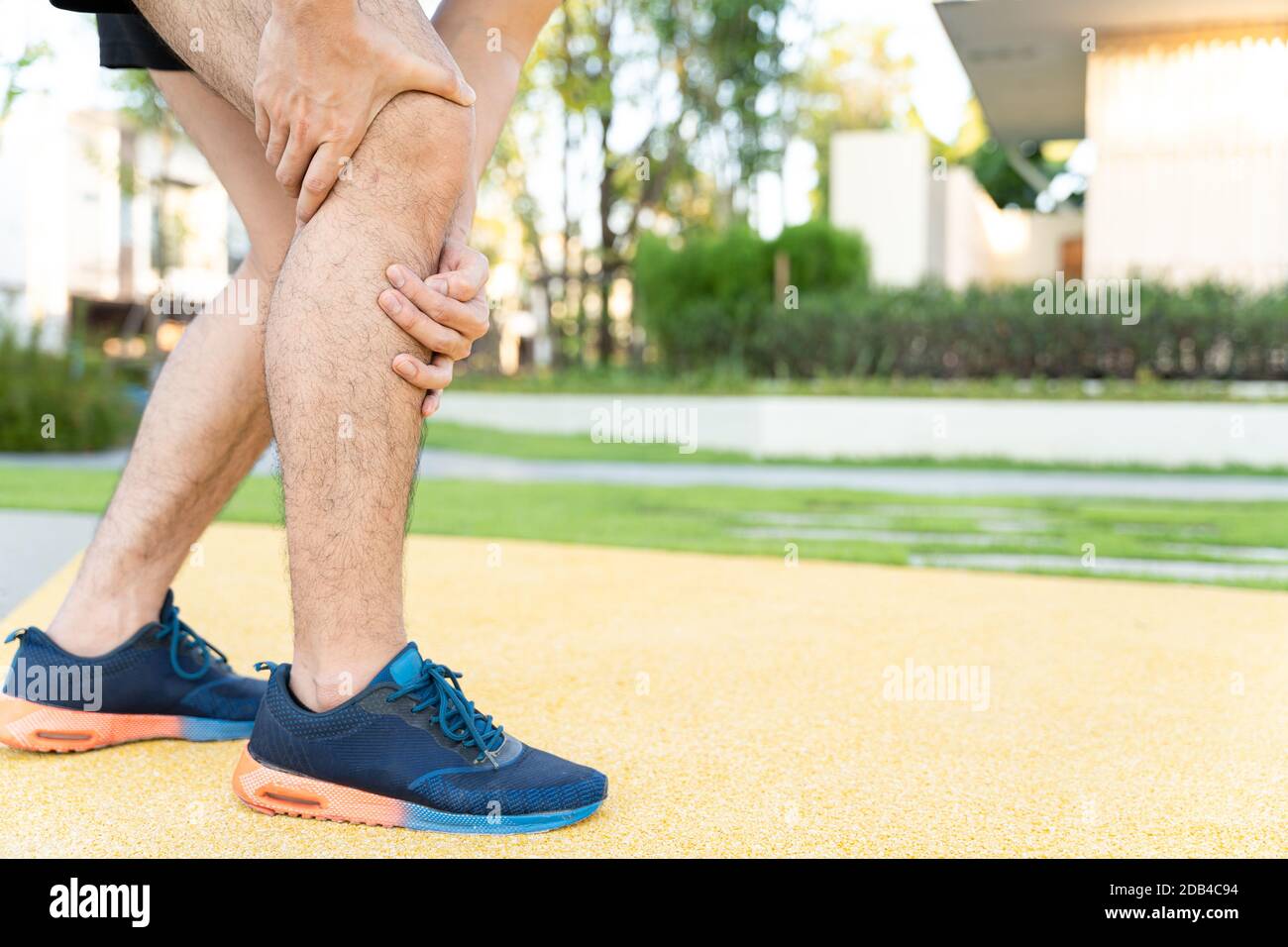 Male runner athlete leg injury and pain. Hands grab painful knee while ...