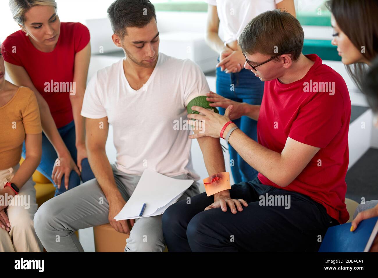 young male instructor show how bandage a hand in a right way, group of ...
