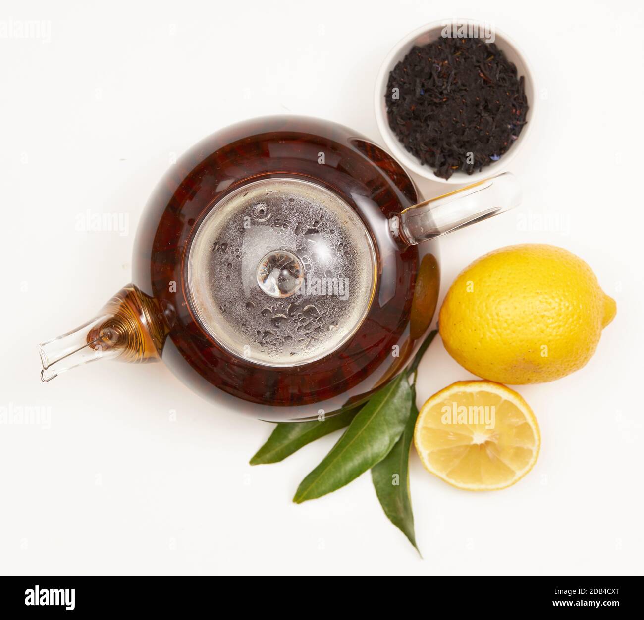 Tea concept,Teapot and cup of tea with green leaves, lemon, top view ...
