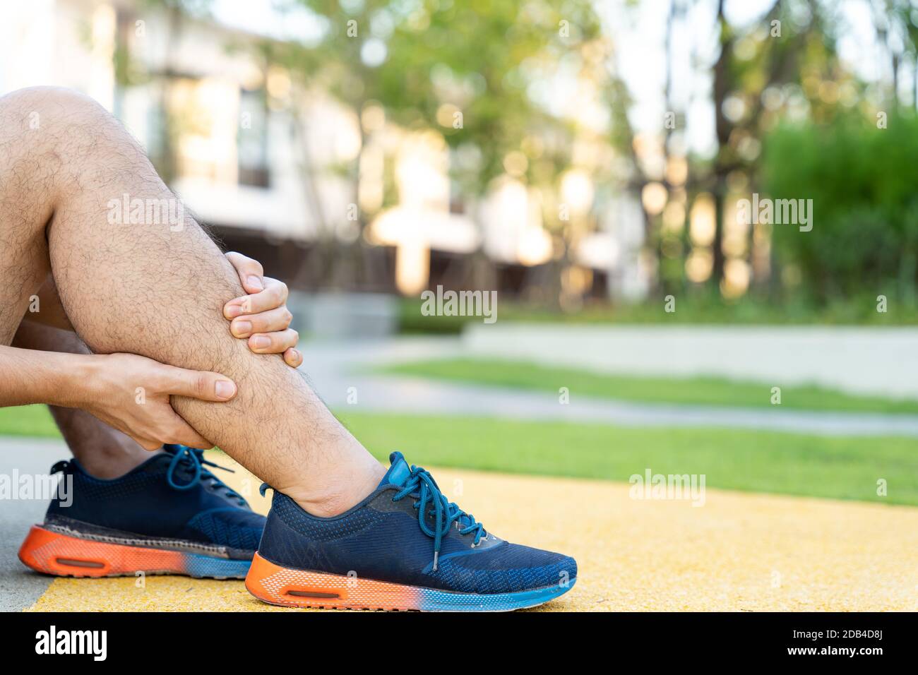 Male runner athlete leg injury and pain. Hands grab painful leg while ...