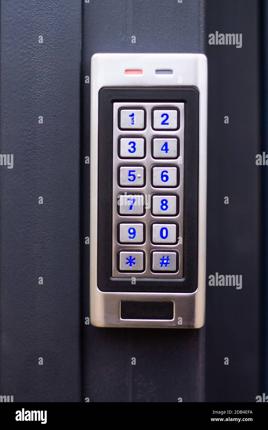 Silver intercom call panel with number pins on a dark metal surface ...