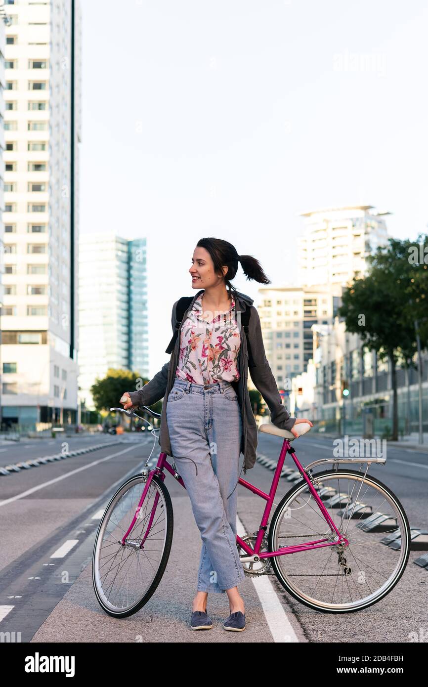 vertical photo of a young girl with a pink retro bicycle standing in ...