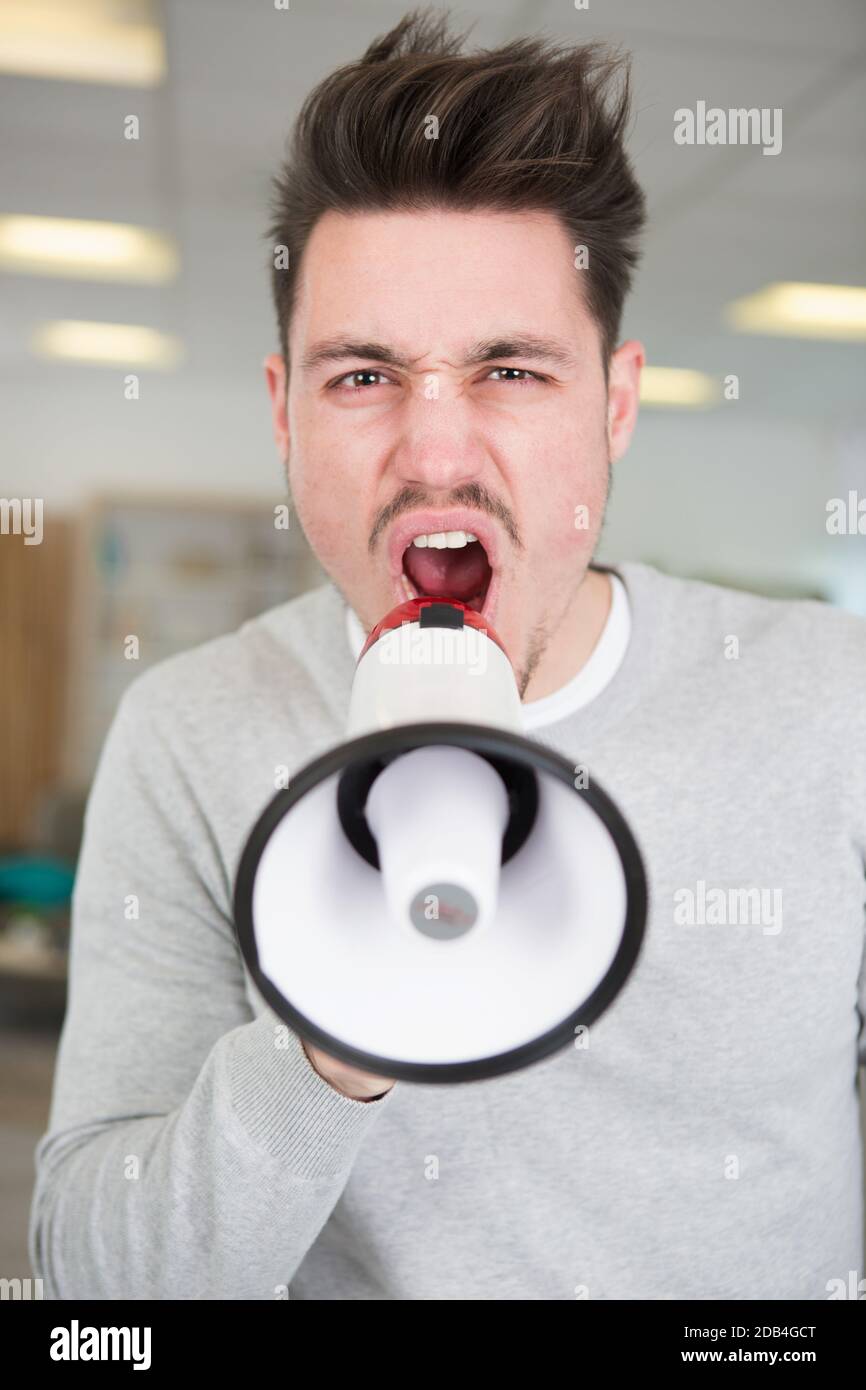 portrait of young man handsome shouting using megaphone indoor Stock ...