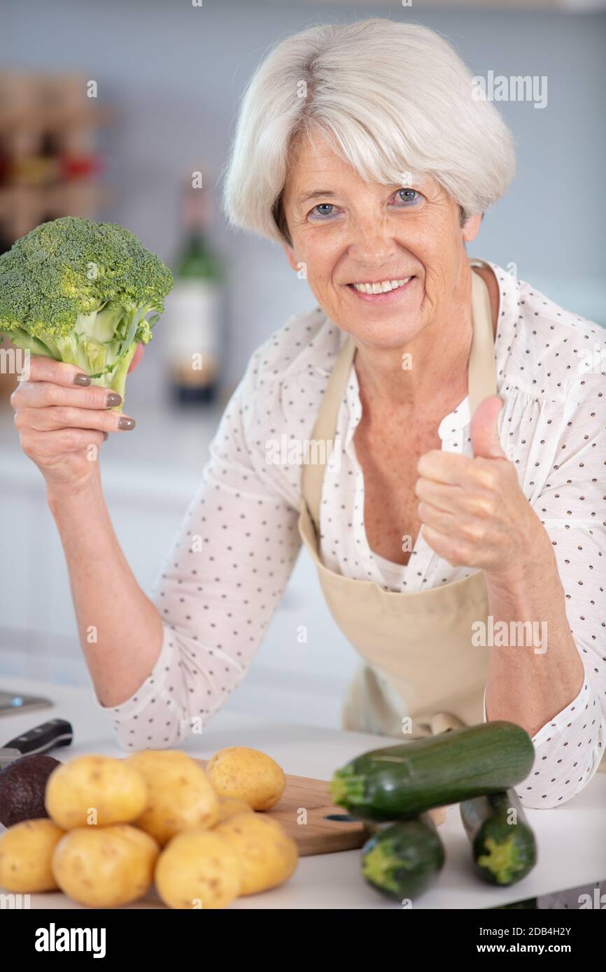 mature woman cooking vegetables in kitchen Stock Photo - Alamy