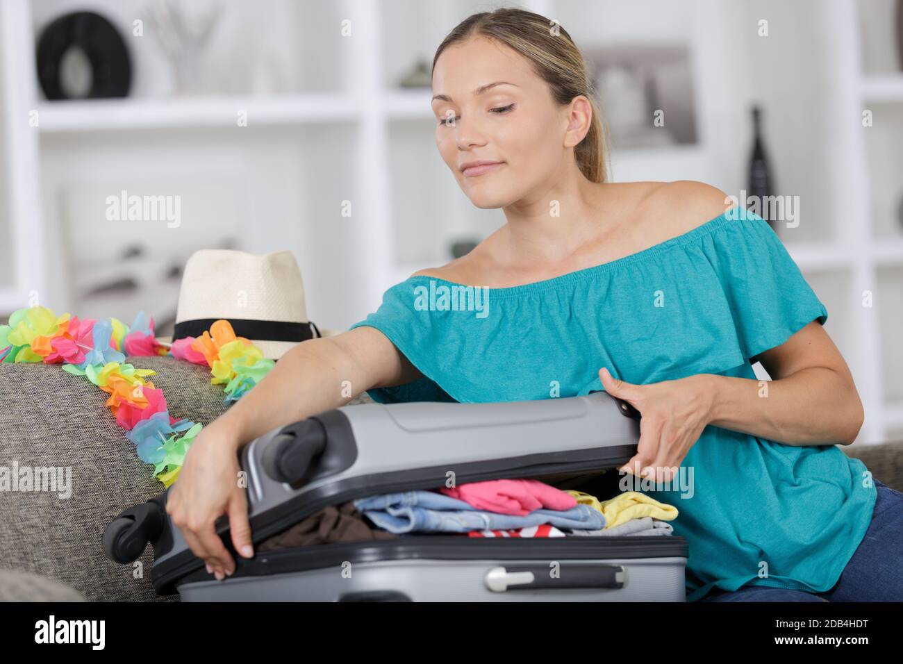 happy young woman packing a suitcase for travel Stock Photo - Alamy