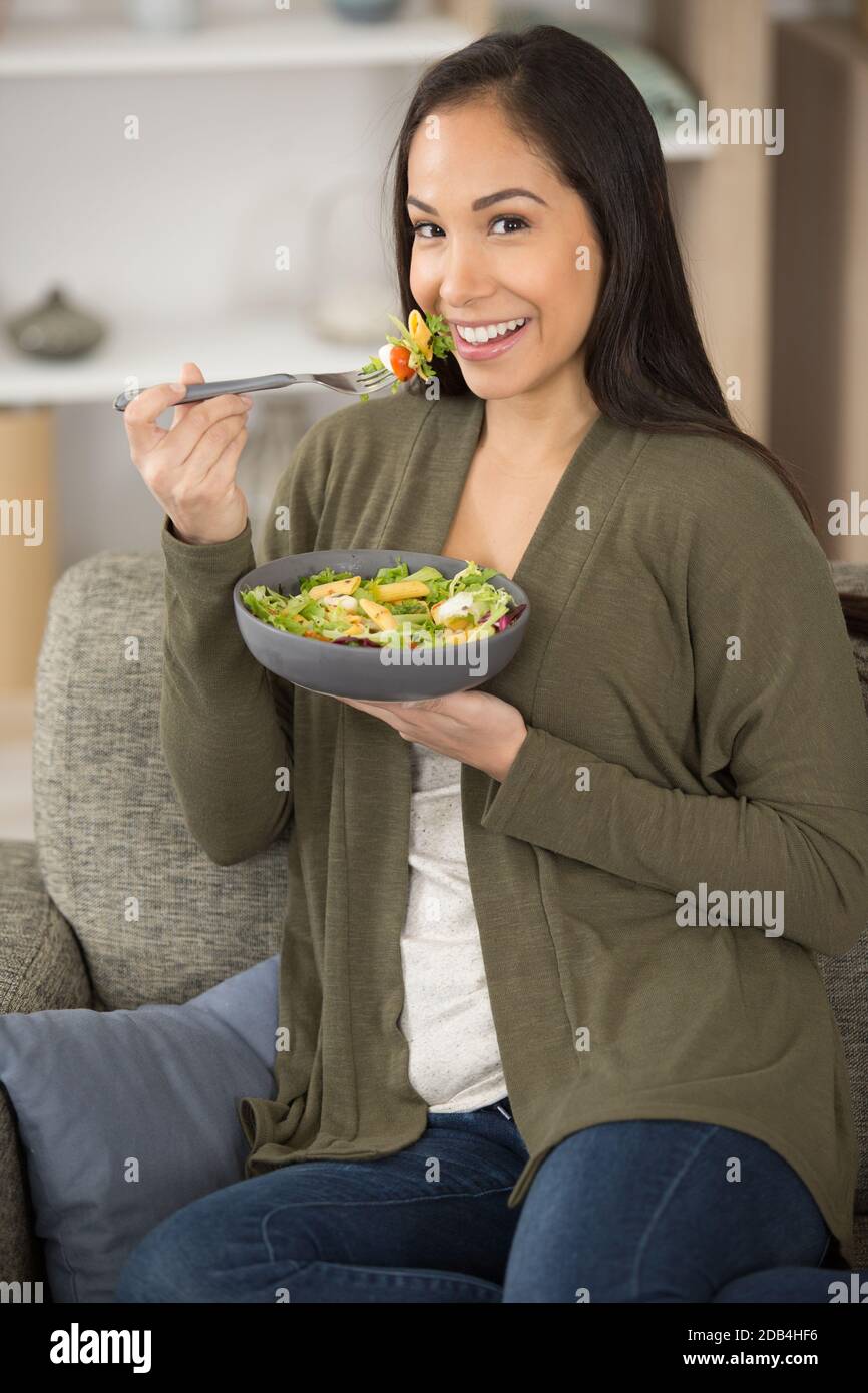 woman sat on the sofa eating a pasta salad Stock Photo - Alamy