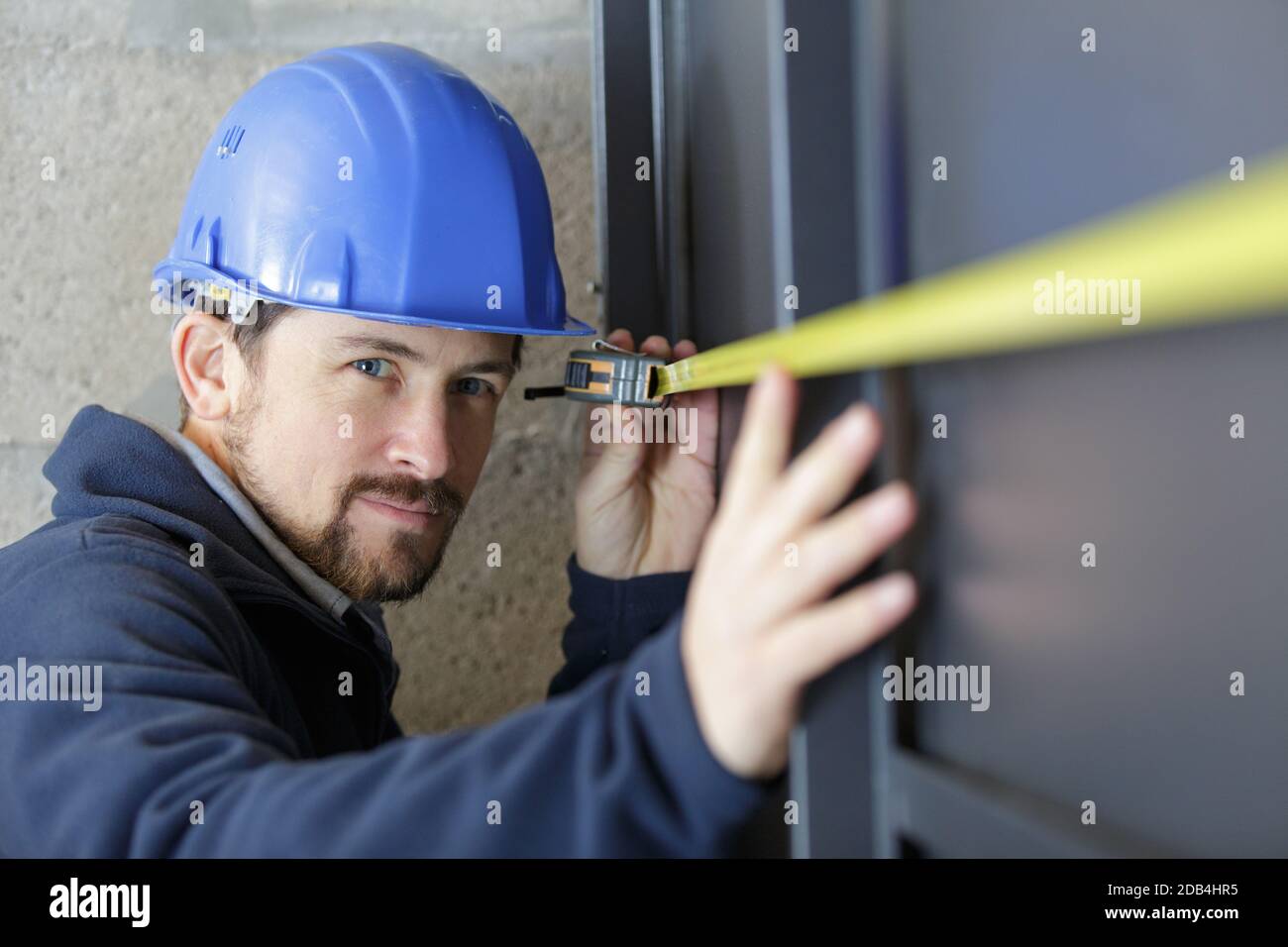 young builder with tape measure Stock Photo - Alamy