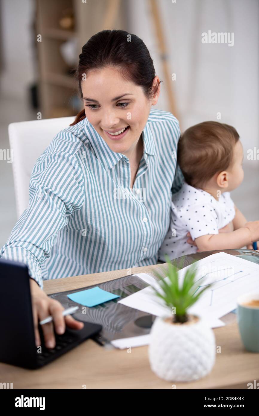 mother and baby using laptop computer in living room Stock Photo - Alamy