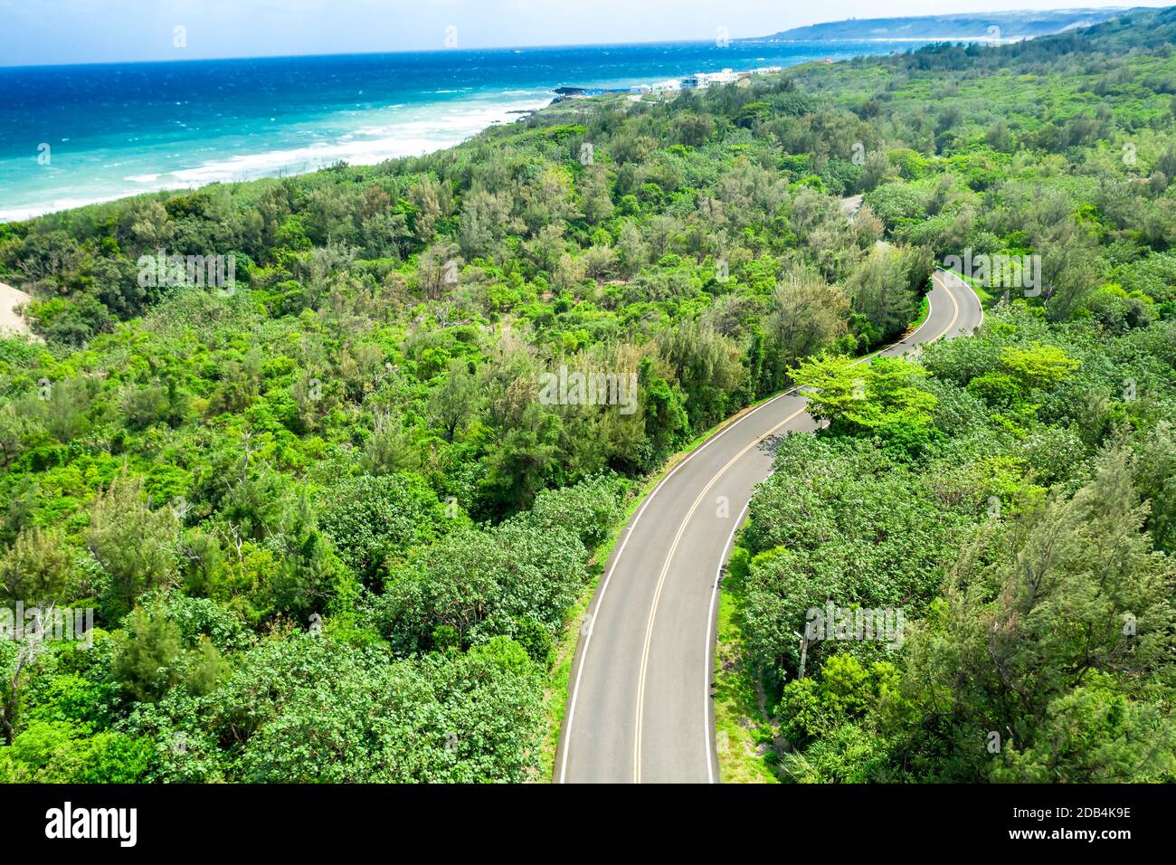 Aerial view of road in beautiful green forest and sea coast Stock Photo ...