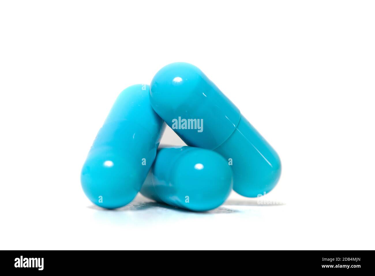 three blue pills over a white background Stock Photo - Alamy