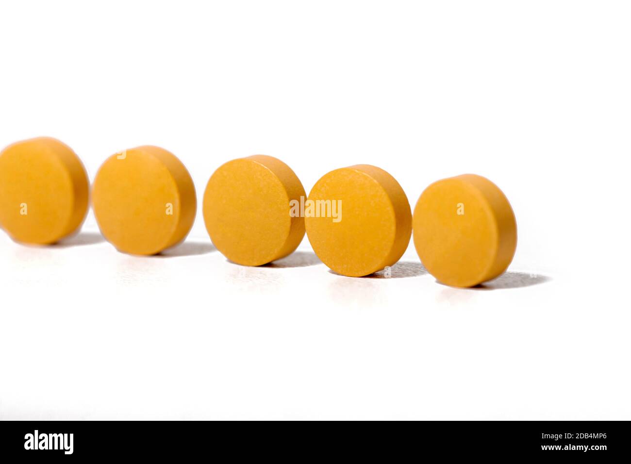 Group of orange pills over a white background Stock Photo - Alamy