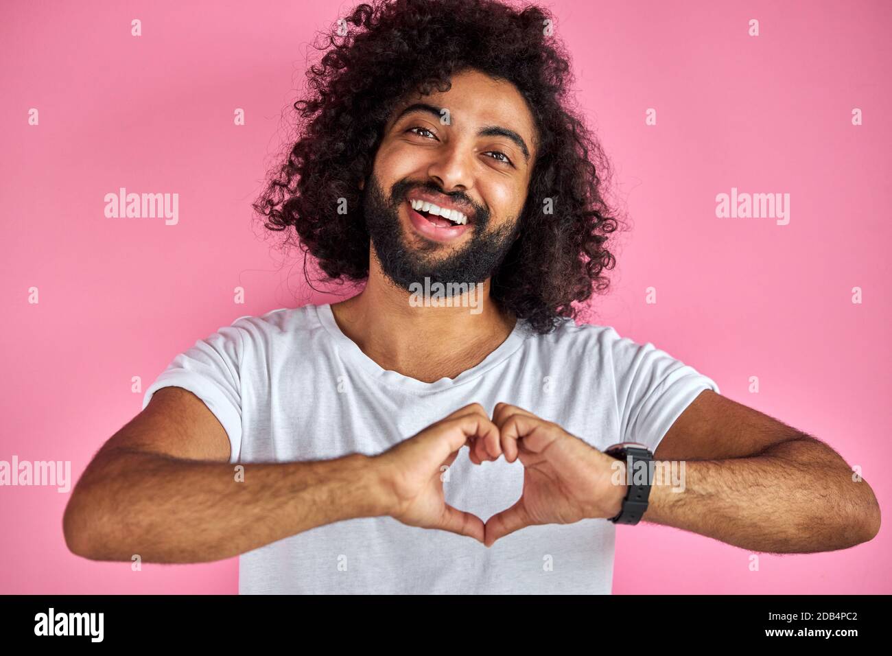 young indian or arabic man smiling in love doing heart symbol shape ...