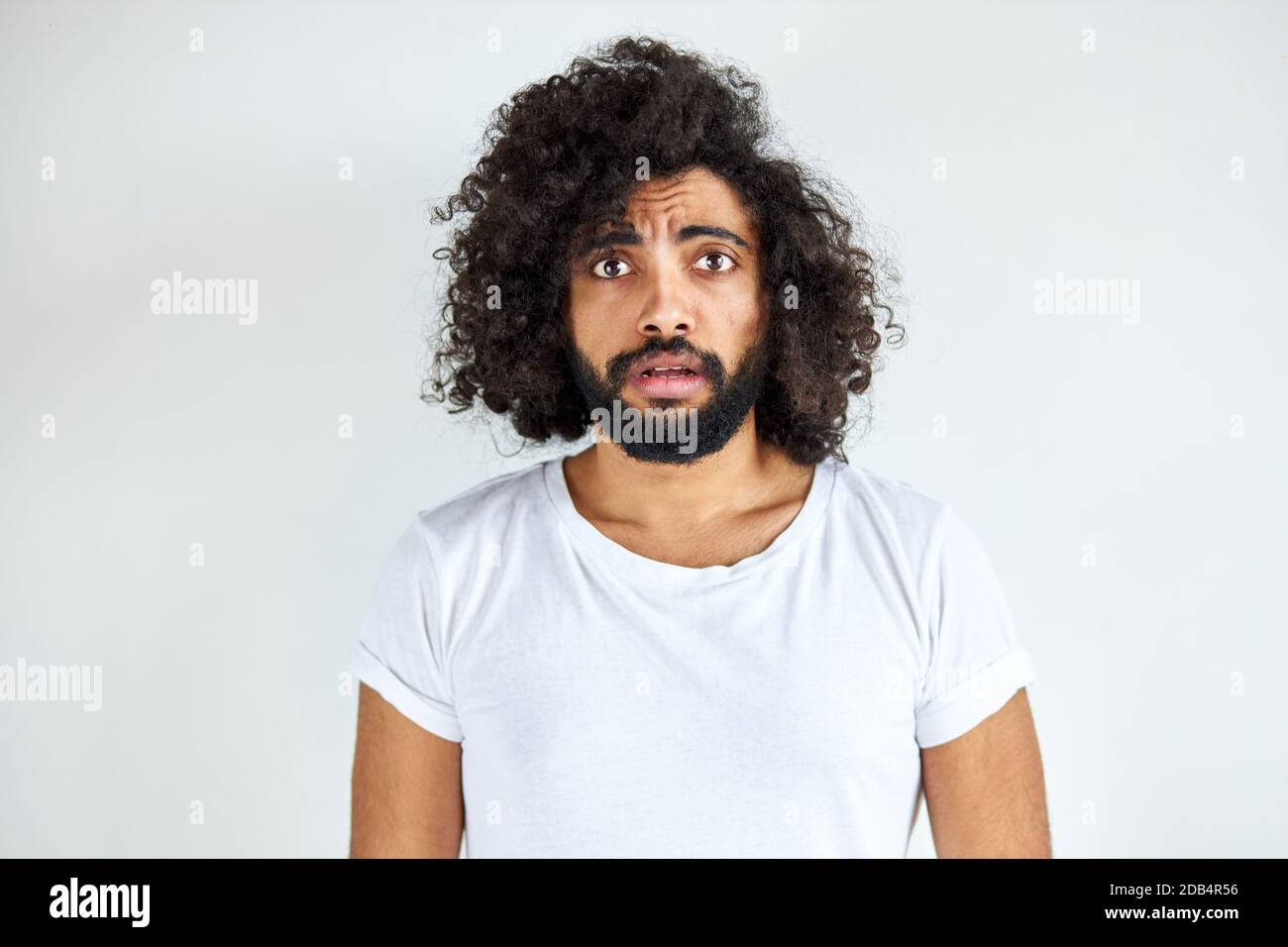 scared curly arabian young guy stand in fear by something, look at ...