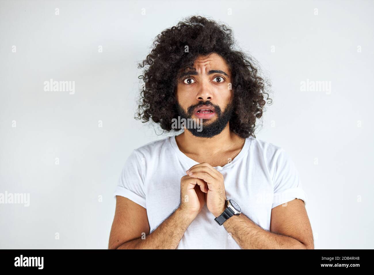 scared curly arabian young guy stand in fear by something, look at ...