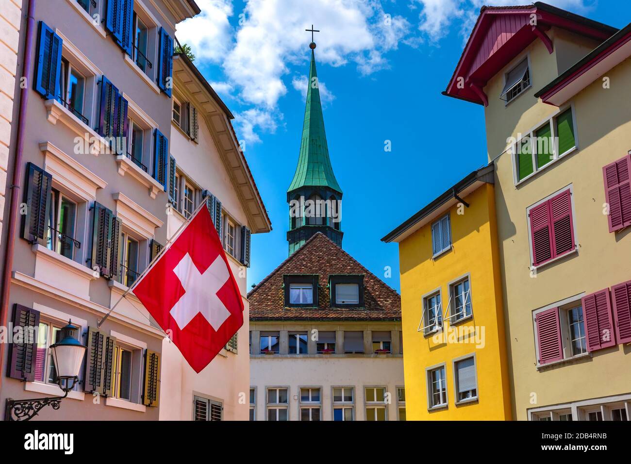 Swiss flag waving, church and colorful facades of houses in Old Town of ...