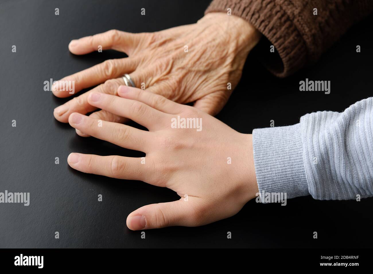 old woman's hand and young man touching her mercifully Stock Photo - Alamy