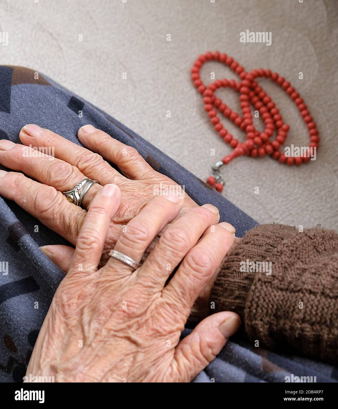 old woman with ring on her finger worships her hand with rosary Stock ...