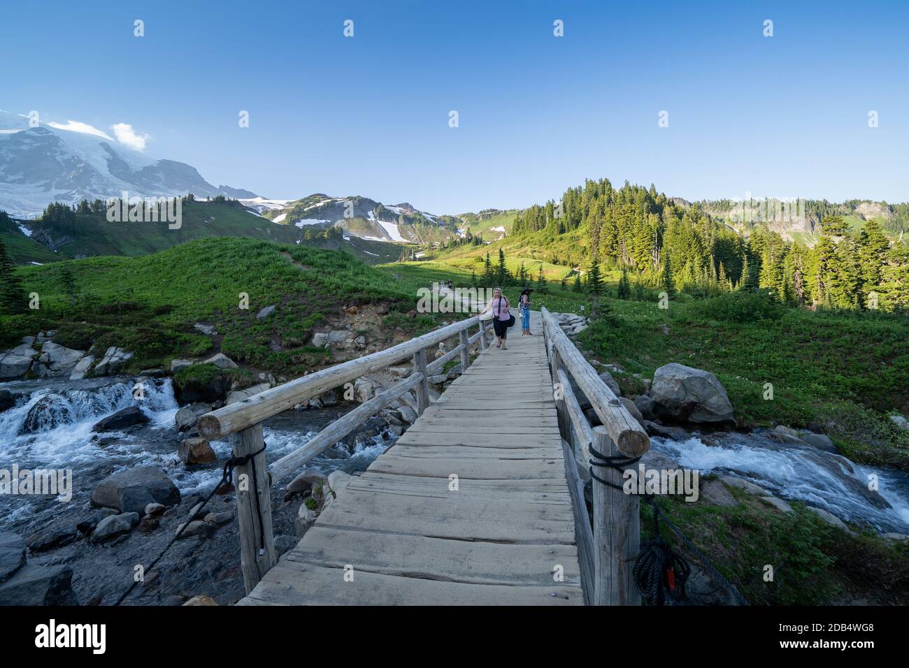 Washington, USA - July 30, 2020: Hikers cross a wooden bridge along a ...