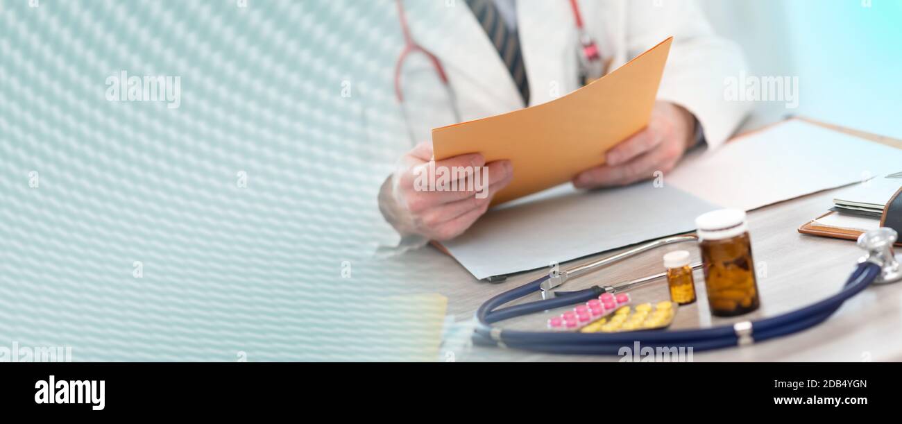 Doctor reading a medical report in office; light effect Stock Photo - Alamy
