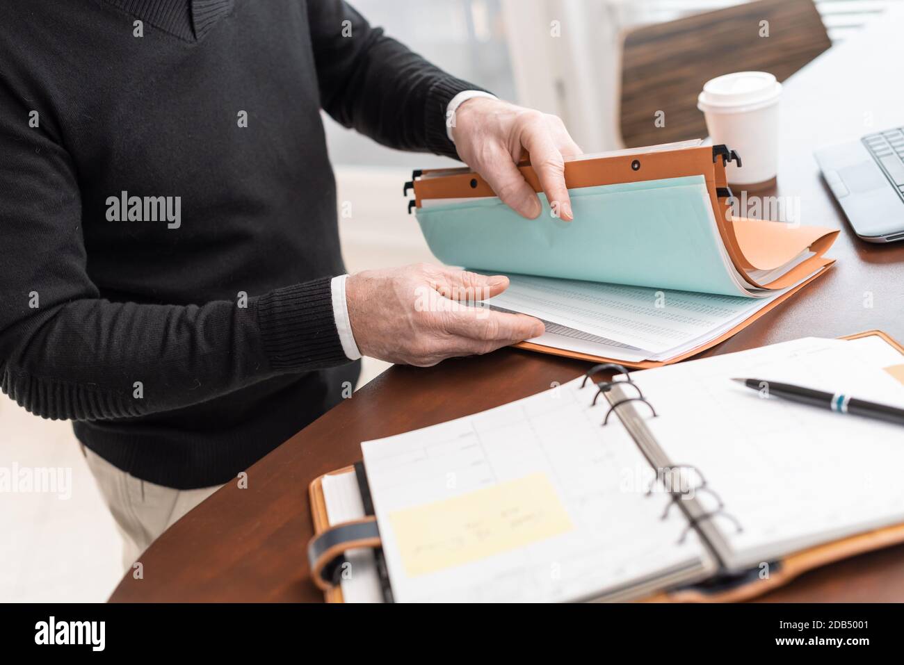 Businessman looking for document in folder at office Stock Photo - Alamy