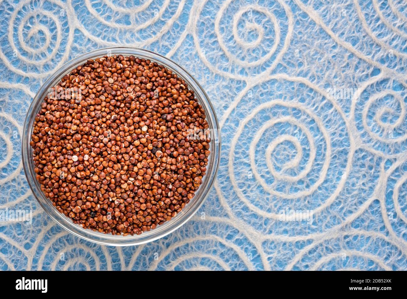 gluten free red quinoa grain in a bowl against lace paper with spiral ...