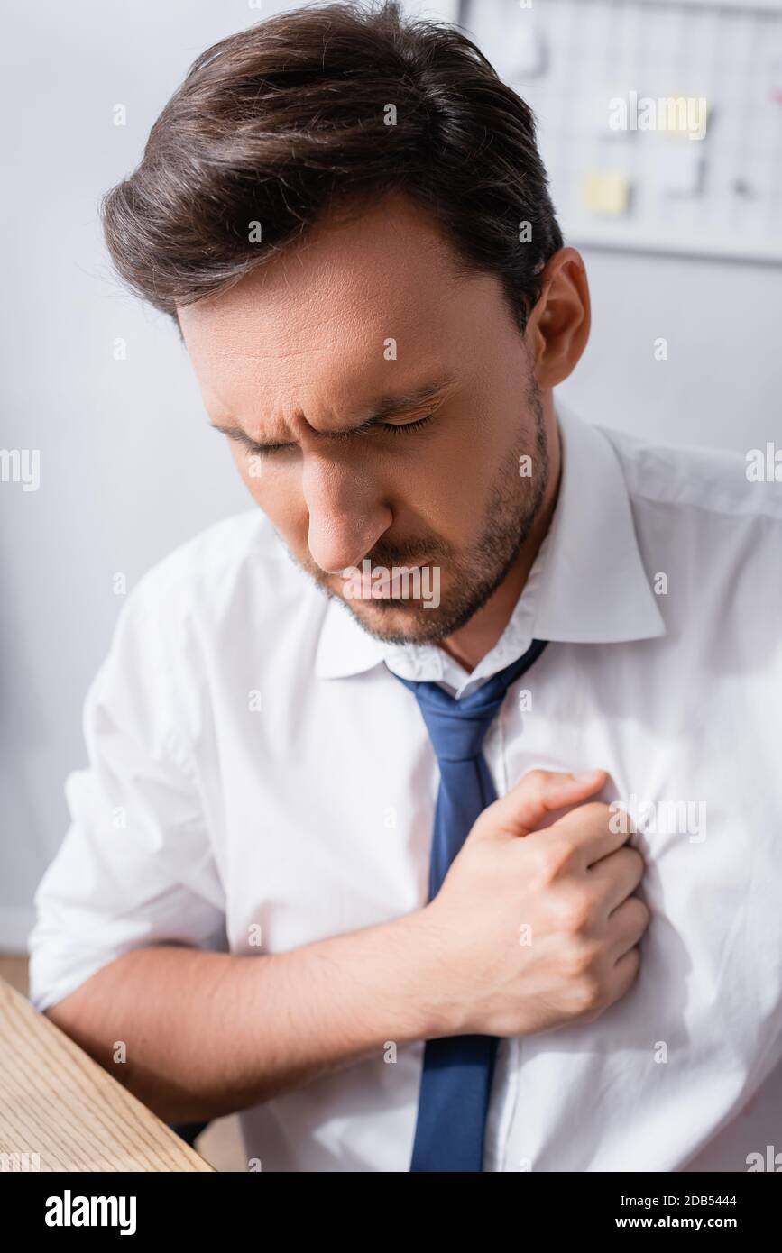 Close up view of office worker suffering from chest pain in office on ...