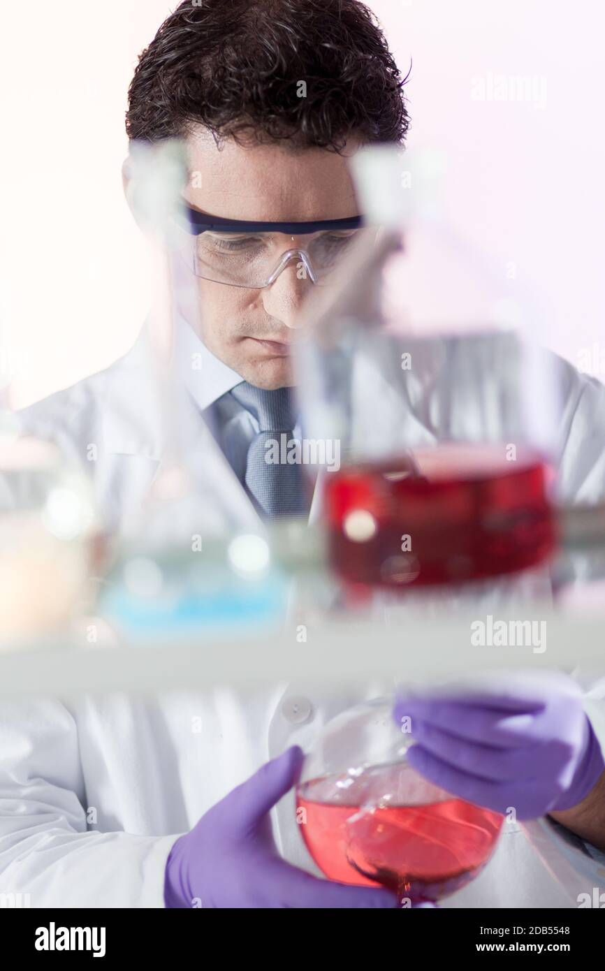 Chemist in chemical laboratory searching for the red indicating ...