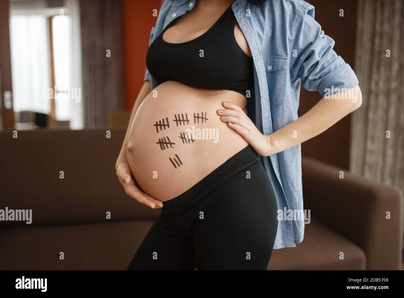 Pregnant woman with belly poses at home, side view. Pregnancy, calm in ...
