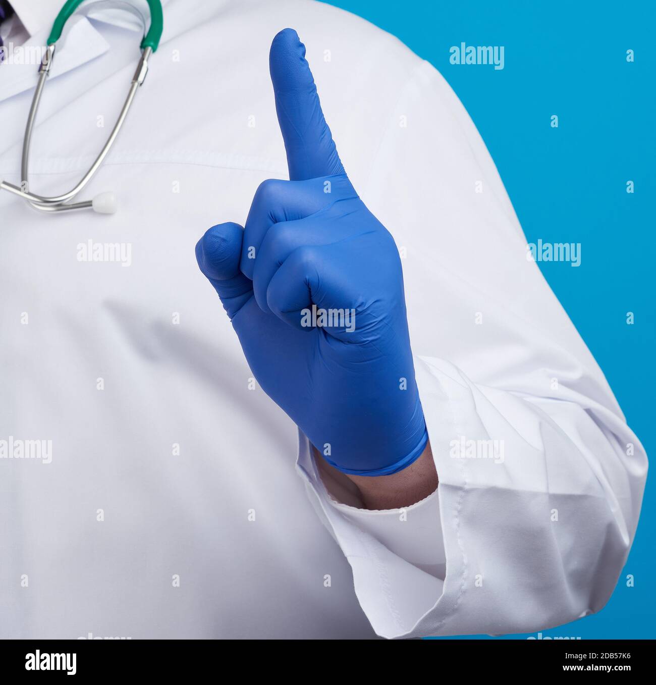 male doctor in white coat, blue medical gloves shows hand gesture of ...