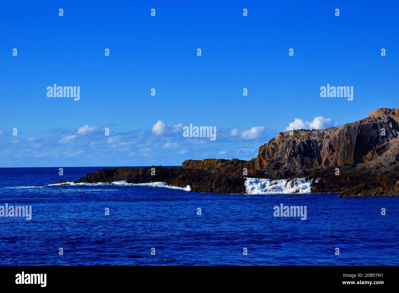 Beach with a small waterfall over rocks Stock Photo - Alamy