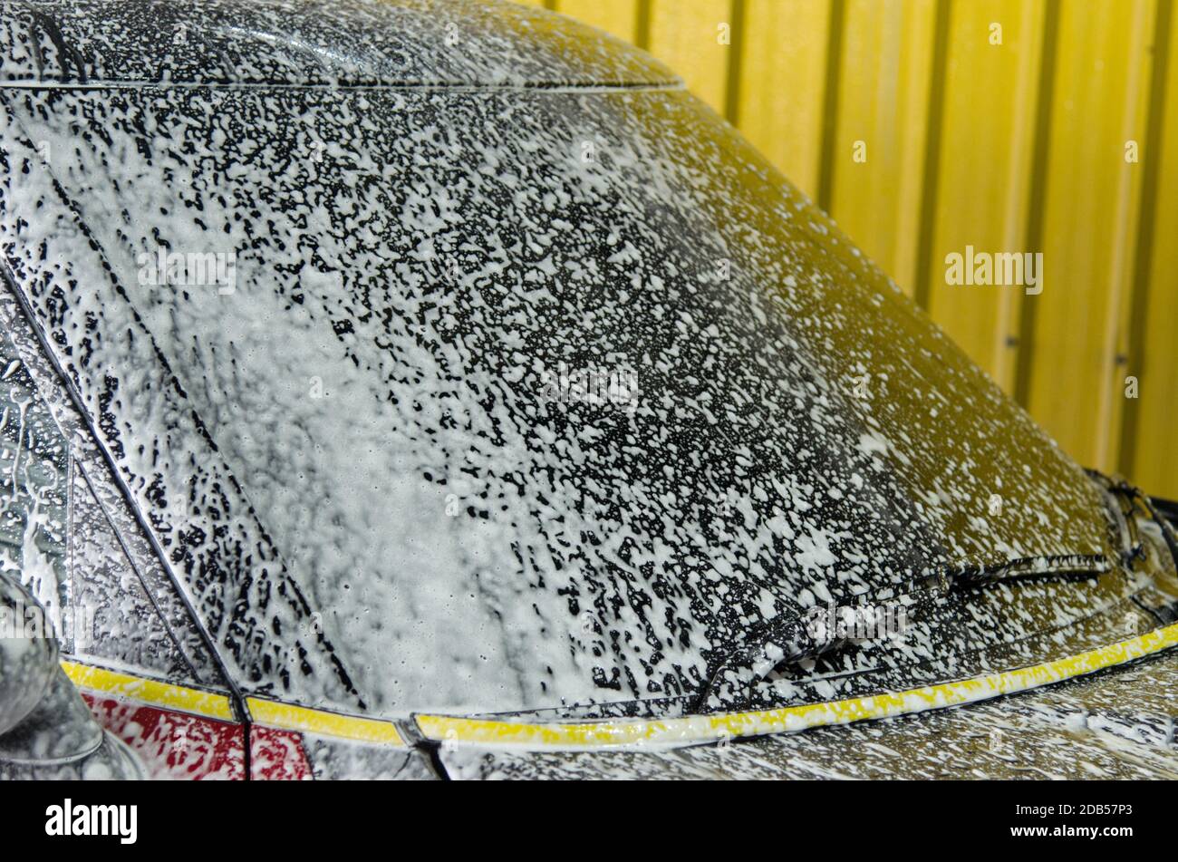 Cleaning red cars. Wash the car at the car wash station with foam ...